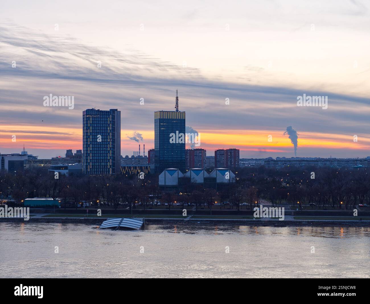 Belgrade urban skyline at dusk with skyscrapers reflecting in calm Sava ...