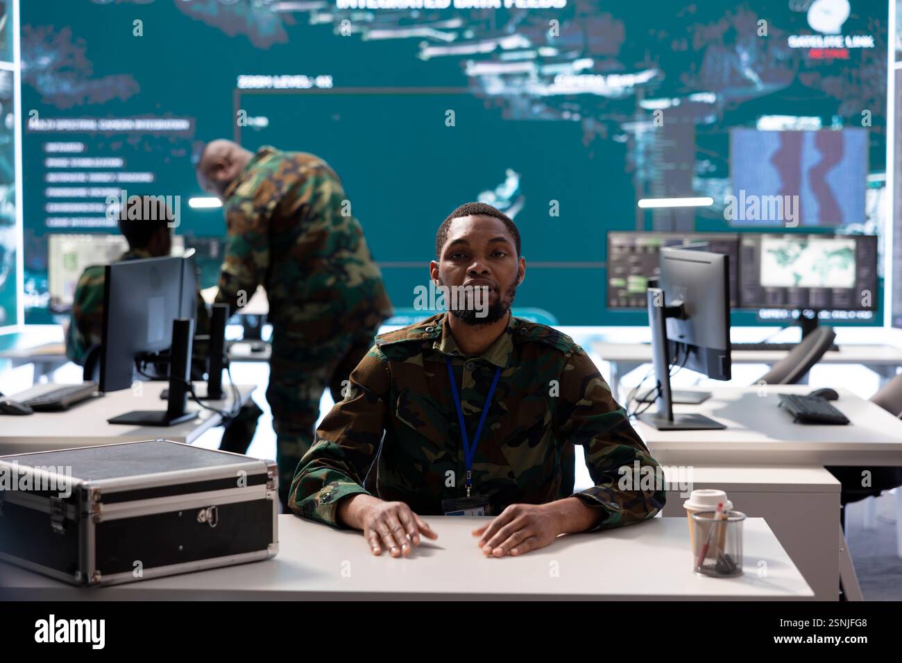 Army soldier in a high tech monitoring room conducts a videocall, leveraging secure ...