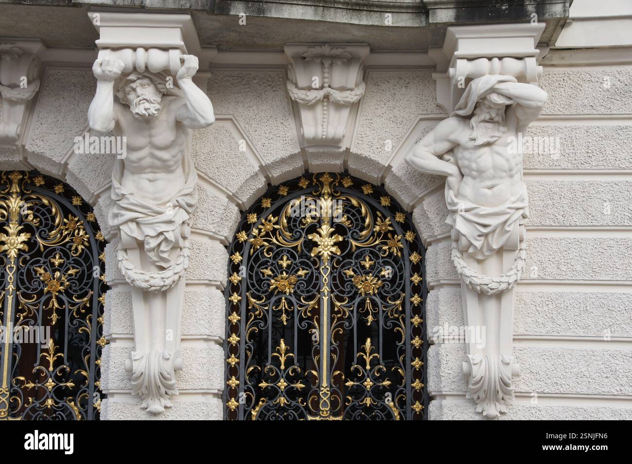 An ornate metal gate on a European-style building is flanked by two ...