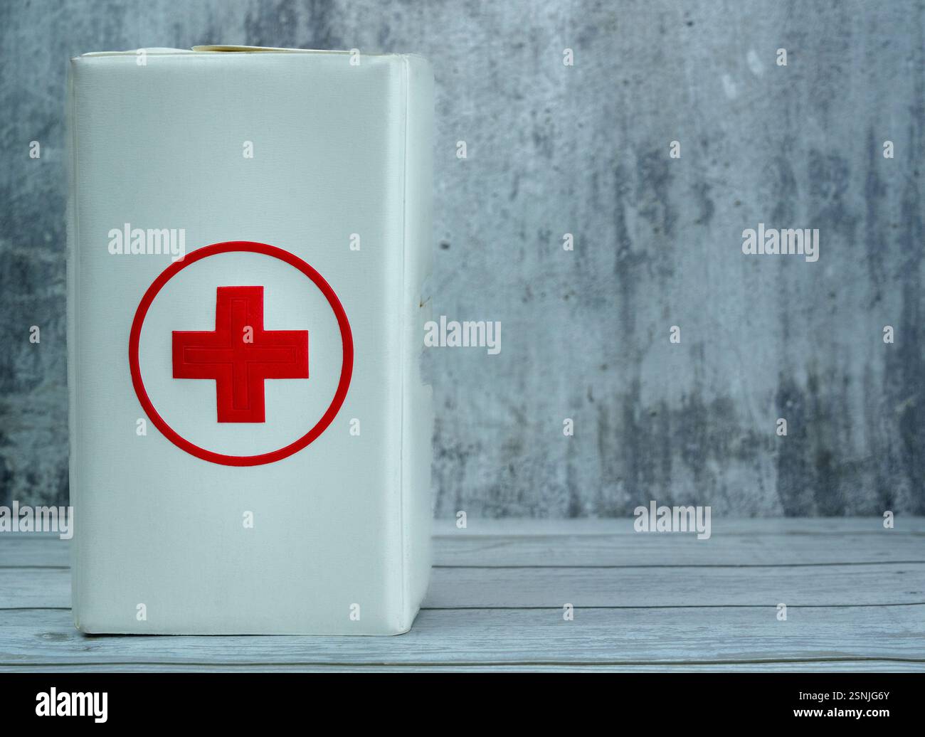 White first aid kit box featuring a red cross symbol, placed on a ...