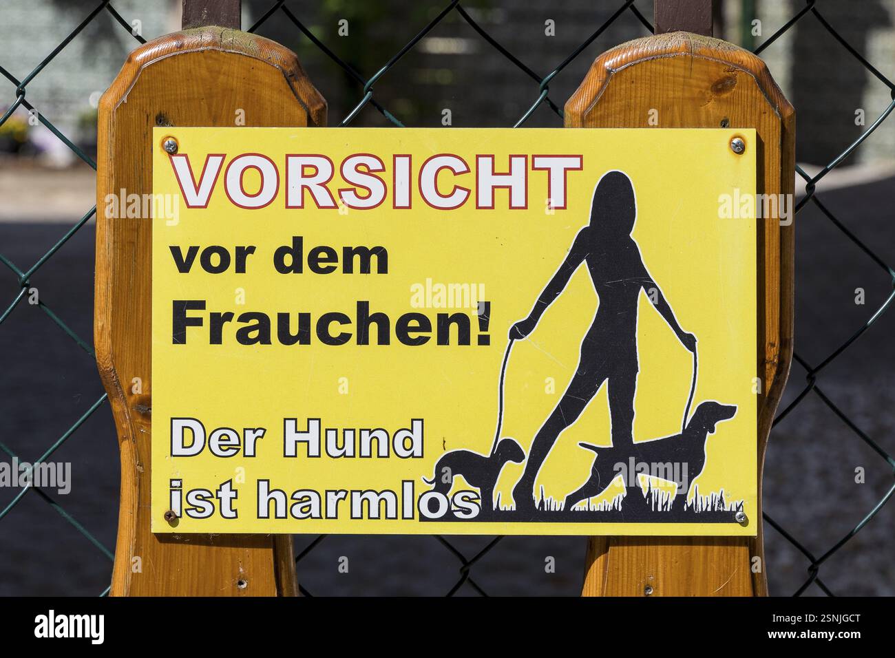 Funny sign on a fence, beware of the mistress, the dog is harmless ...