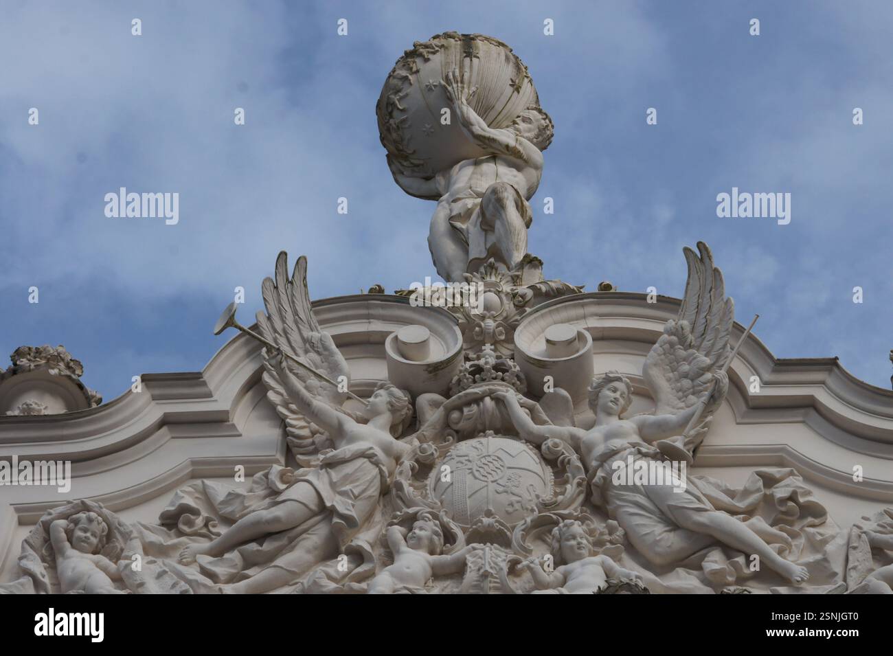 Germany, Munich. Atop a white building, a statue of a winged man holds ...