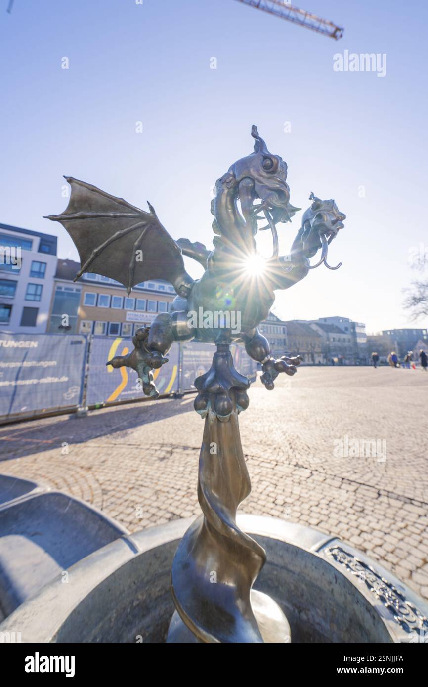 Metal sculpture of a dragon with sunlight in the background ...