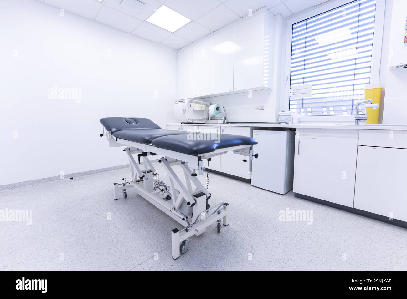 Modern clinic room with examination couch and window, bright and ...