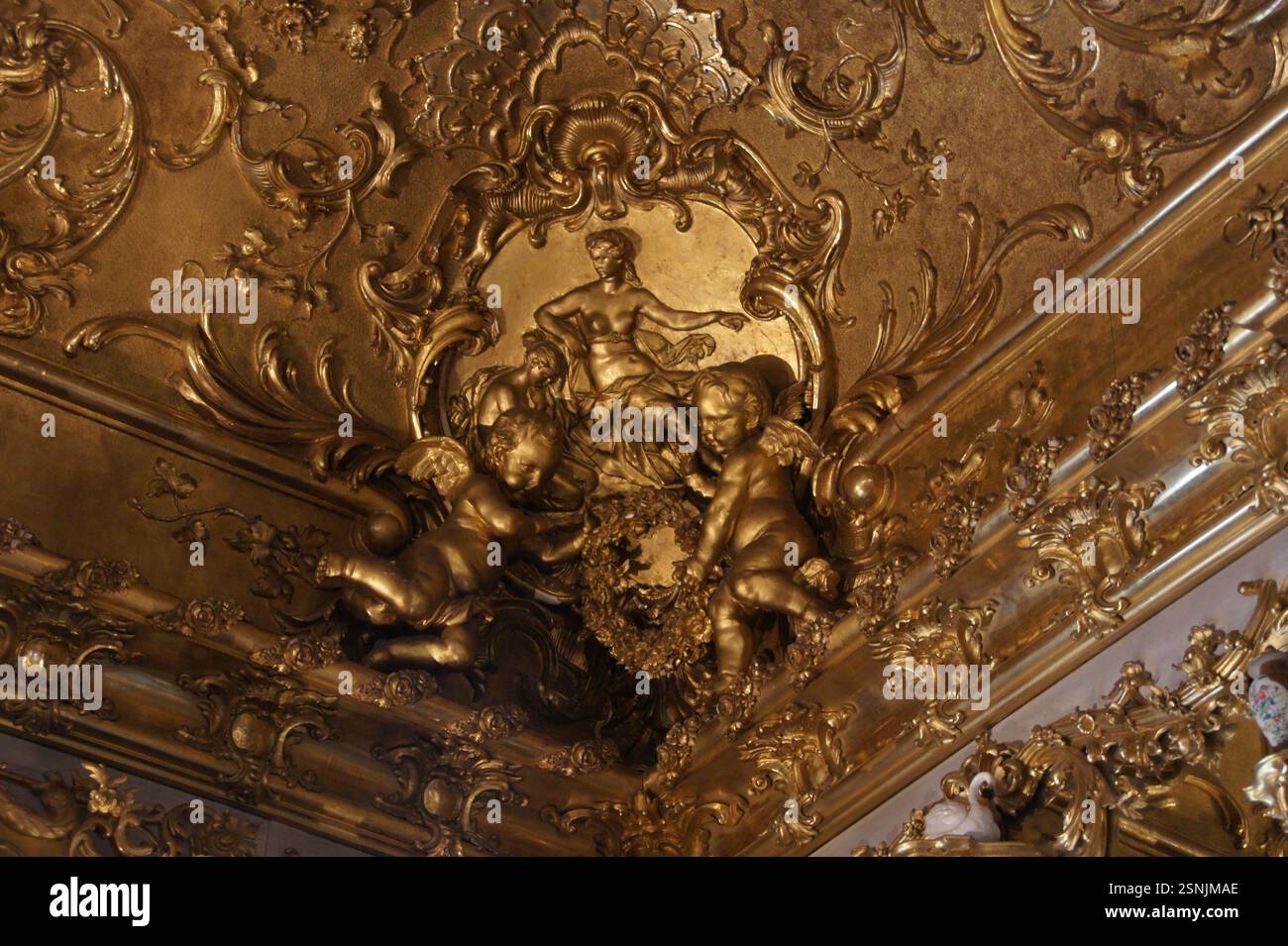An ornate gold ceiling in Munich, Germany, features a central carving ...