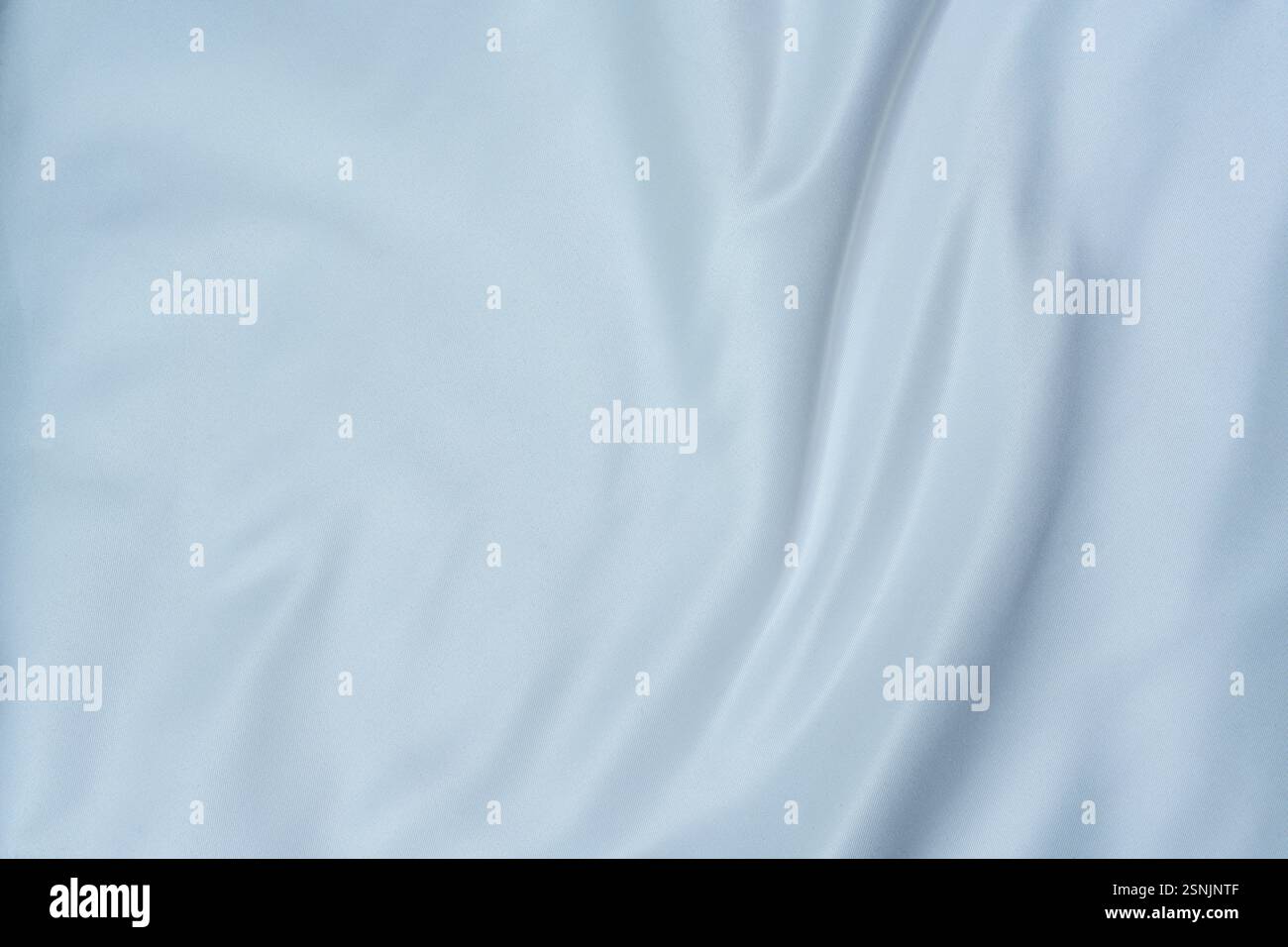 Close-up of soft white fabric with gentle folds creating a swirl ...