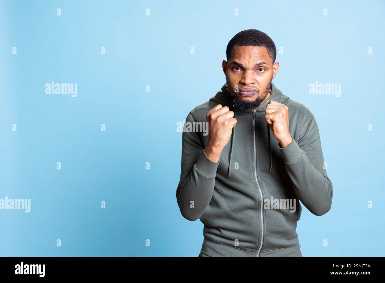 Active athletic african american guy clenching his fists on camera ...