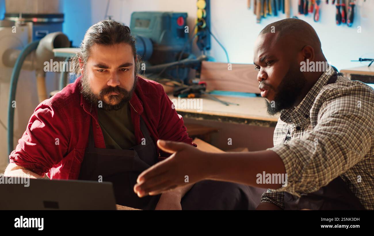 Woodworkers using CAD software on laptop to design wooden objects ...