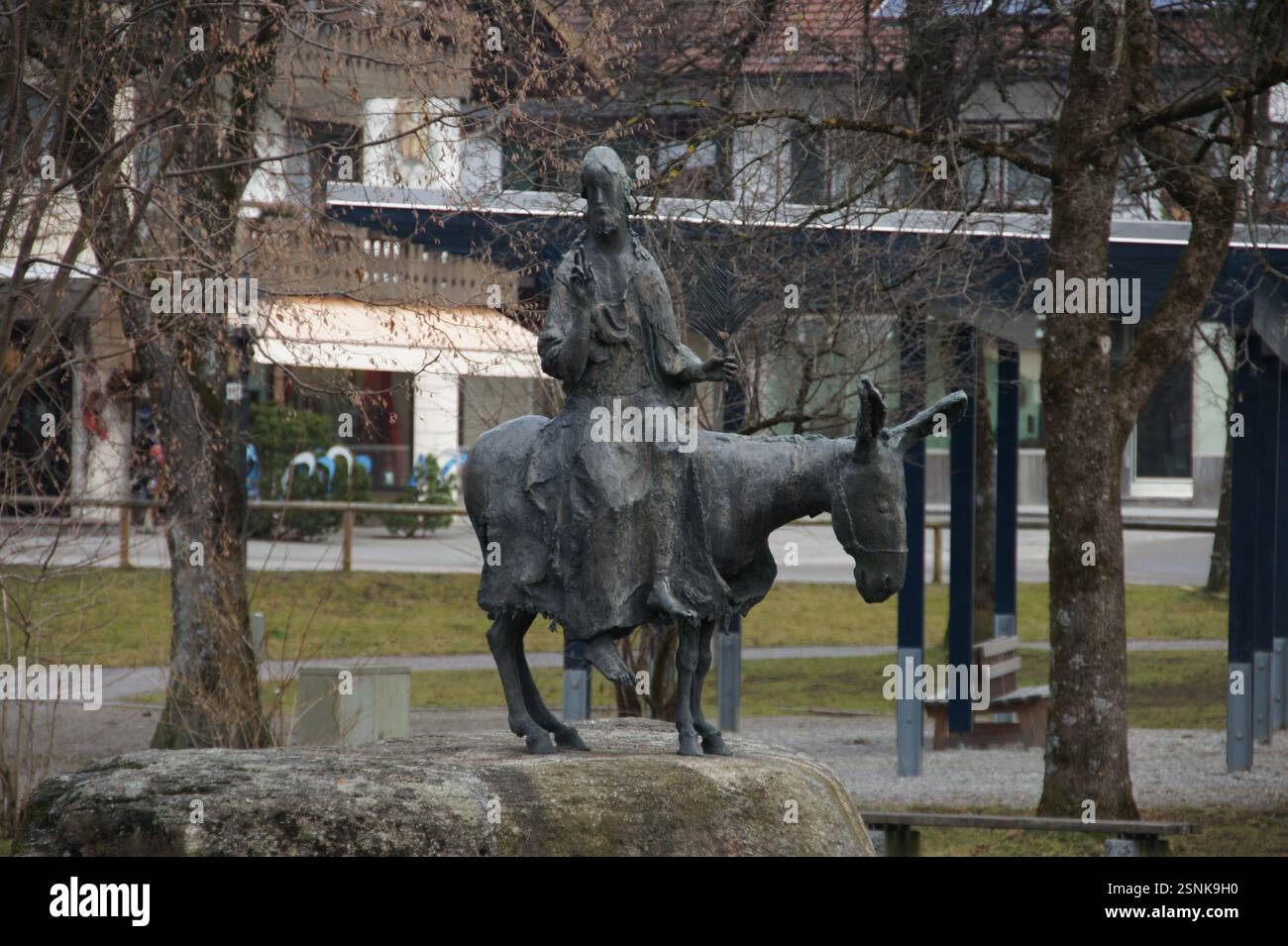 A bronze statue of a young woman in a long dress, riding a donkey in a ...