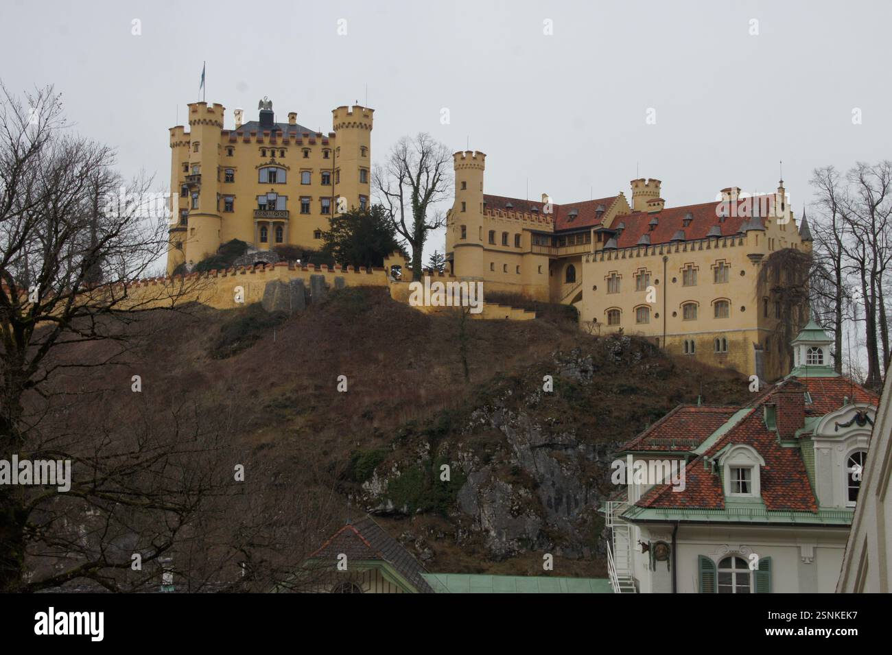 Two castles stand on a hill overlooking a lake in the Bavarian Alps ...