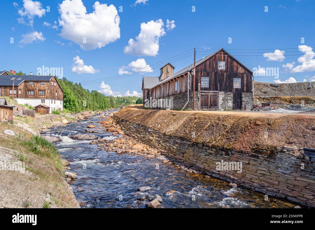 Traditional wooden houses on the banks of the river in the mining ...
