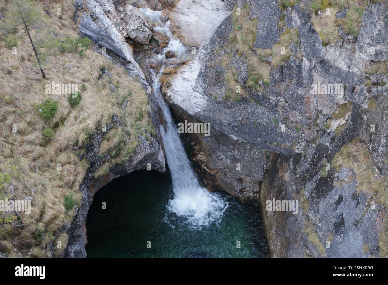 A cascading waterfall in Germany, Munich, surrounded by lush greenery ...