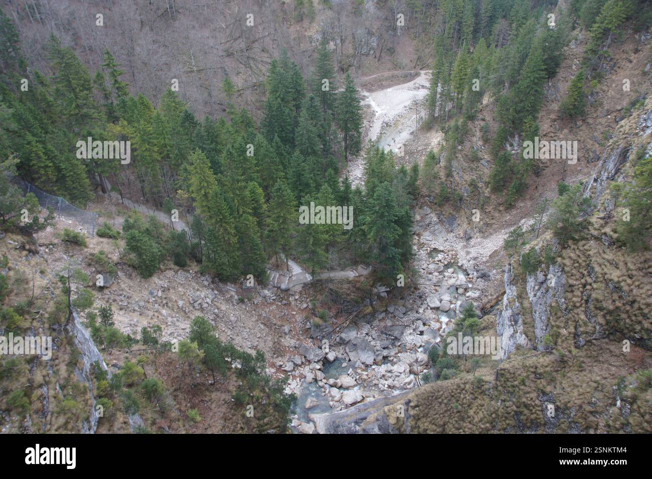 A lush green canyon with a river winding through it. The steep canyon ...