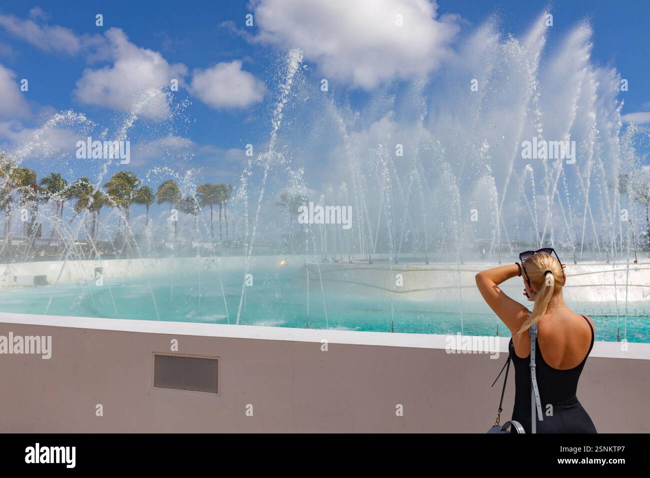 A woman takes pictures of the mesmerizing water display at the Bayfront ...