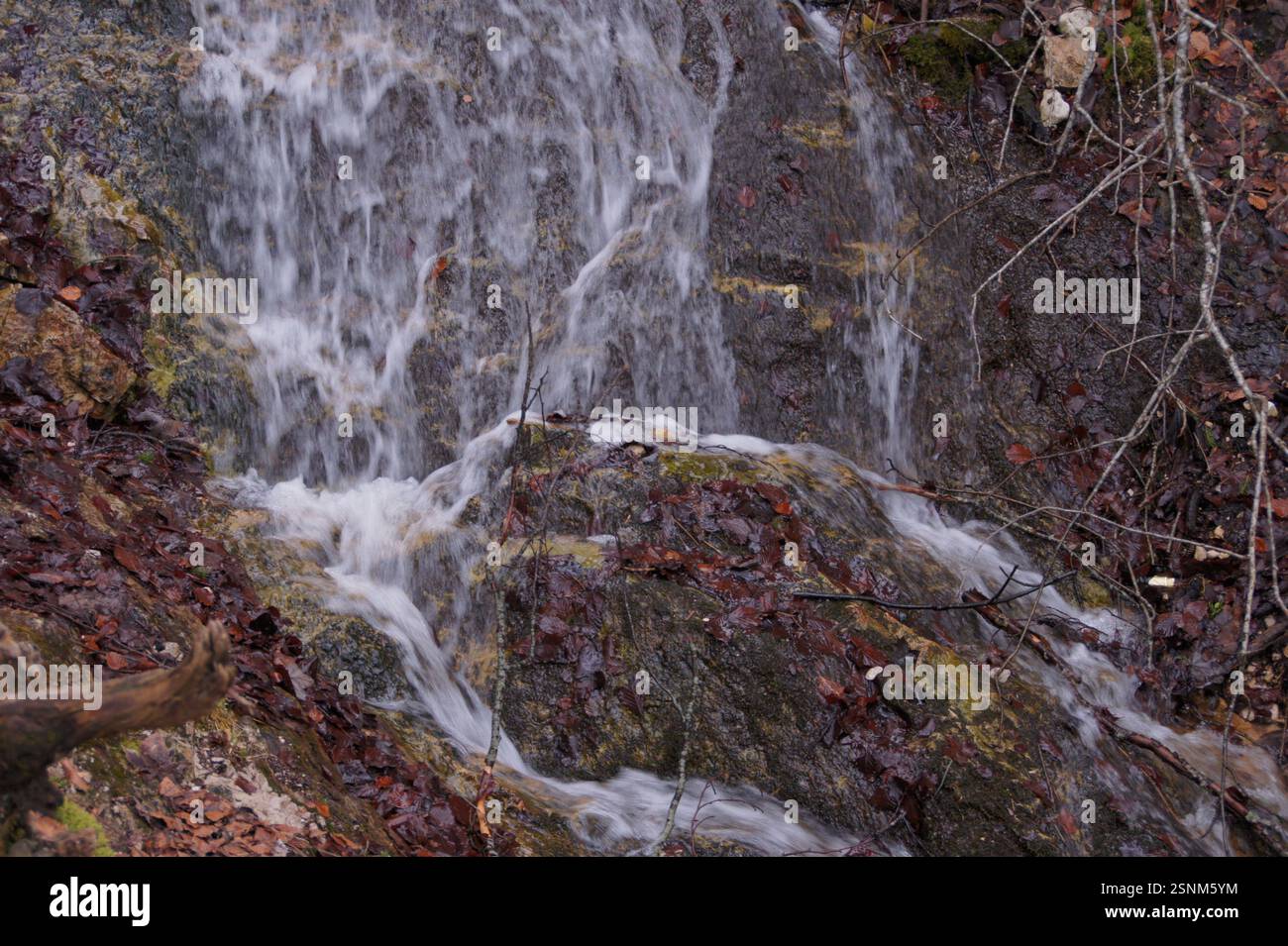 A small waterfall cascades over moss-covered rocks in Germany, Munich's ...