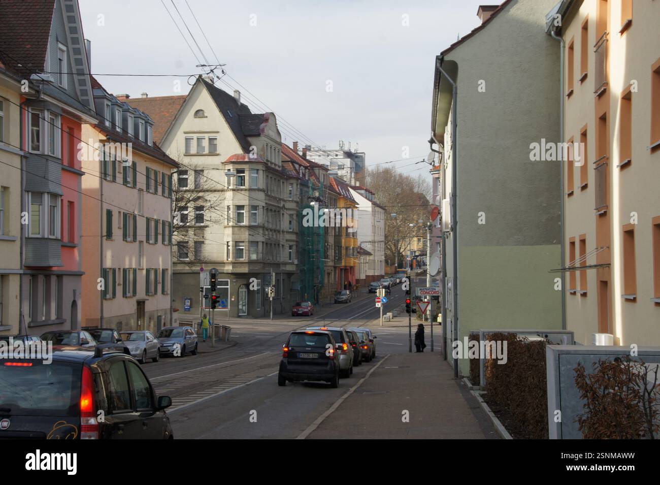 Germany, Munich. A bustling city street lined with parked cars and ...