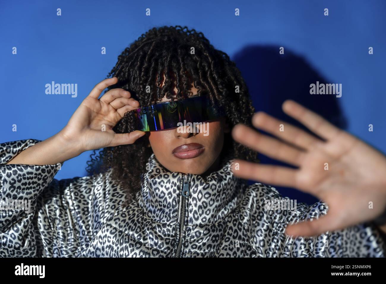 Stylish model with futuristic visor raises hand in stop gesture ...