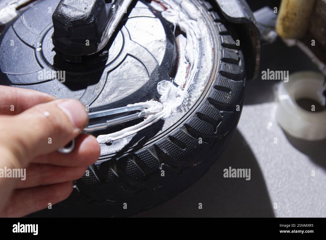 Close-up of adhesive being applied to tire lining of an electric ...