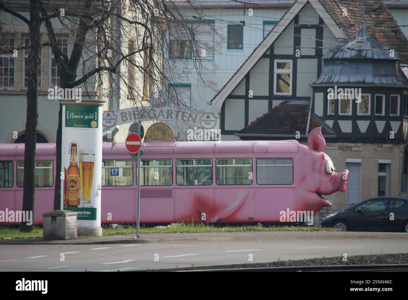 A pink pig-shaped bus with text on the side advertises a Biergarten ...