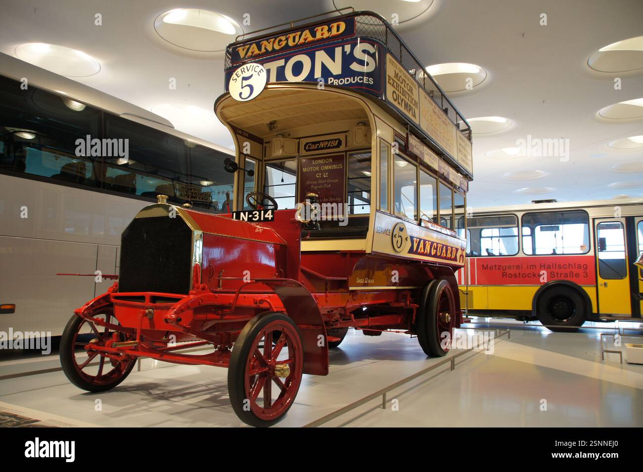 A vintage red London bus with wooden wheels gleams in a Munich, Germany ...