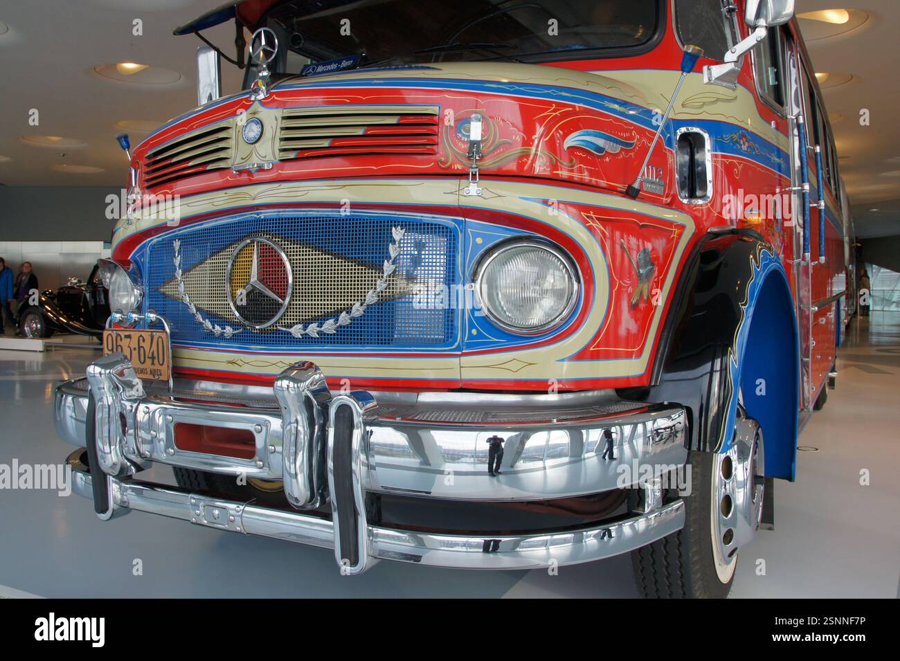 A vibrantly painted Mercedes-Benz bus with gleaming chrome accents ...