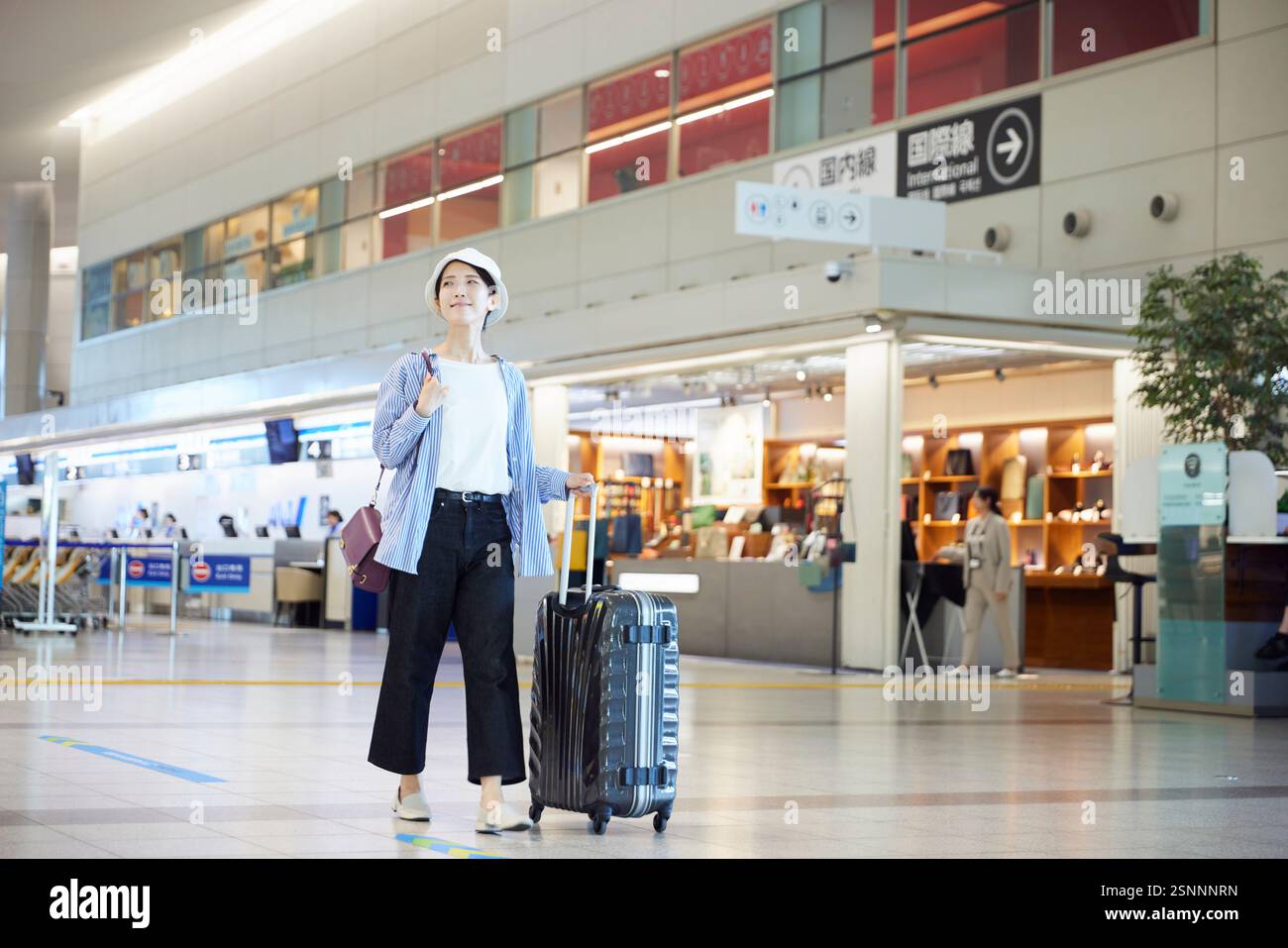 Japanese woman travelling walking through the airport Stock Photo - Alamy