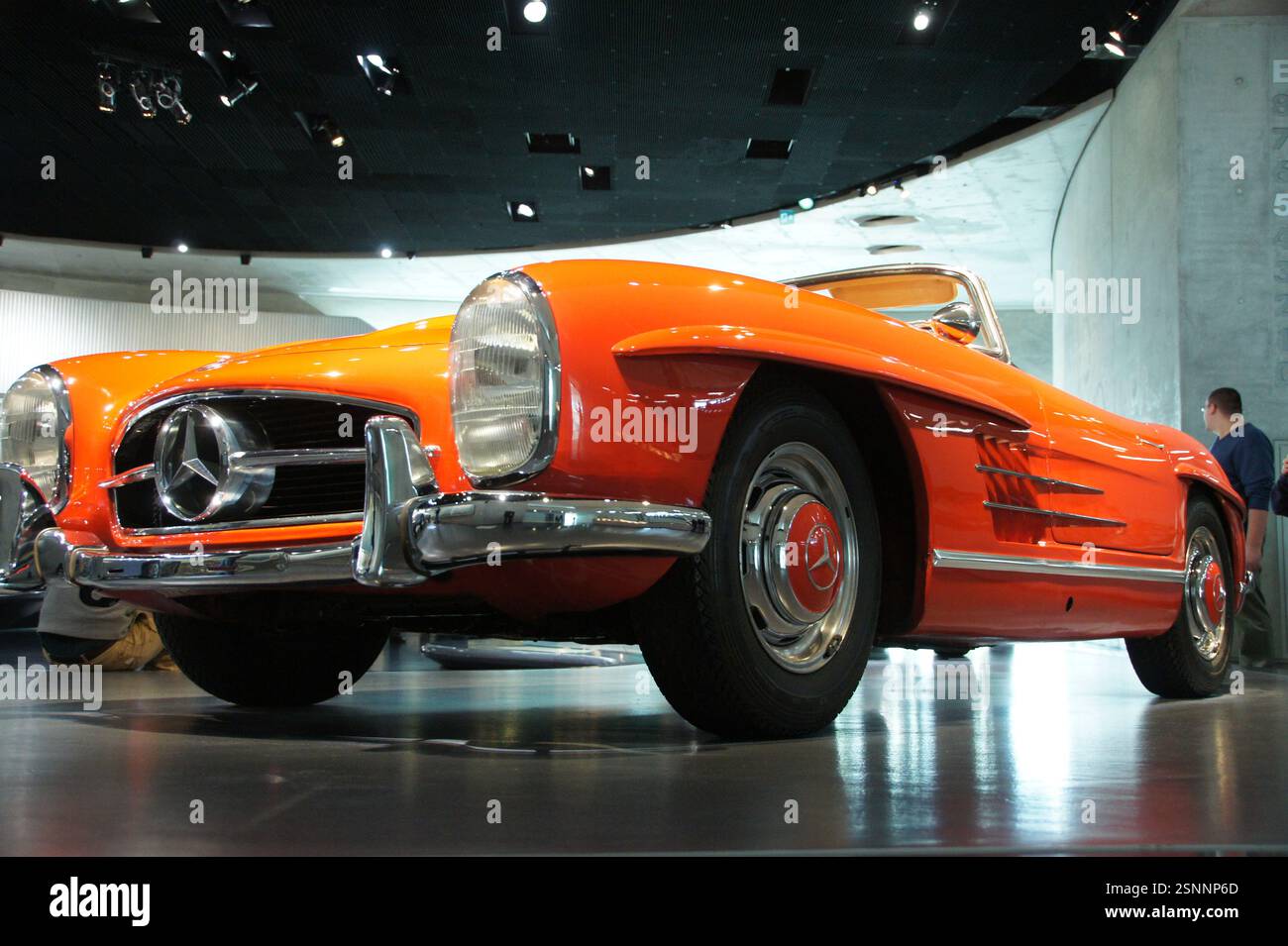 Germany, Munich. A gleaming orange Mercedes-Benz 300 SL Roadster graces ...