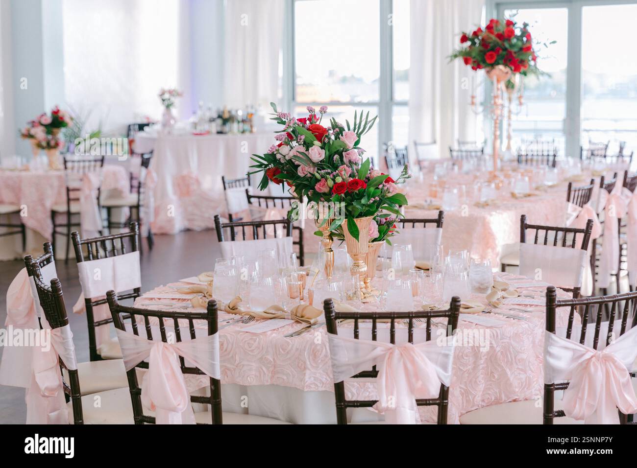 A beautifully decorated event space featuring round tables with floral ...