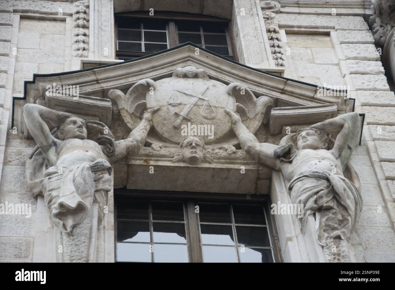 In Germany, Munich, a stone facade with intricate carvings. Two angelic ...