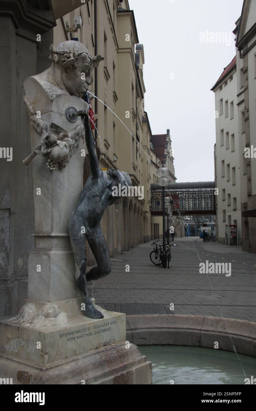 A grotesque figure spitting water adorns a stone fountain on a historic ...