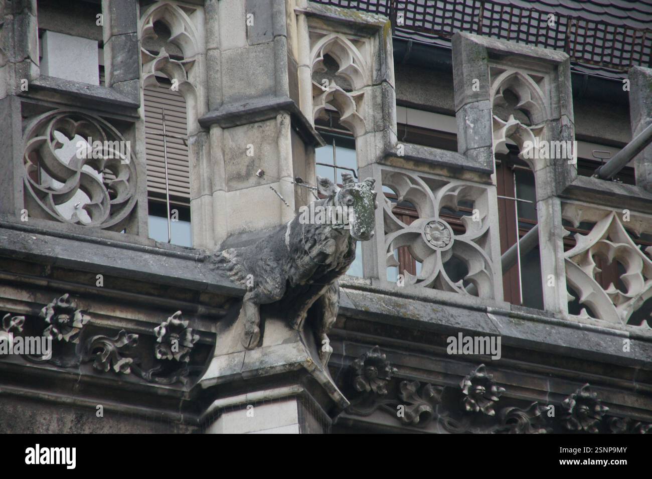 A grotesque stone gargoyle with exaggerated features perches on a ...