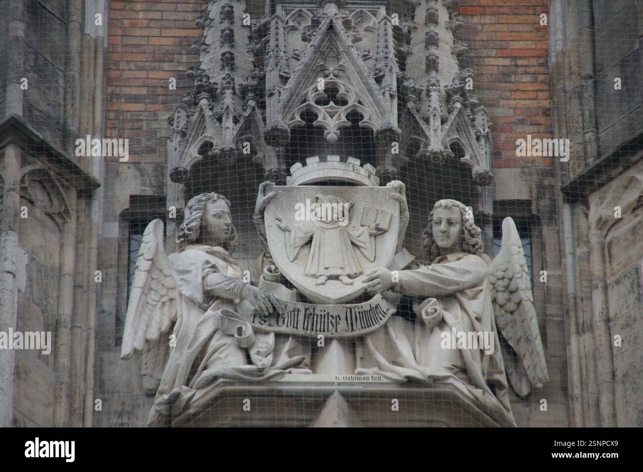 In Germany, Munich, a stone sculpture depicts two angels flanking a ...