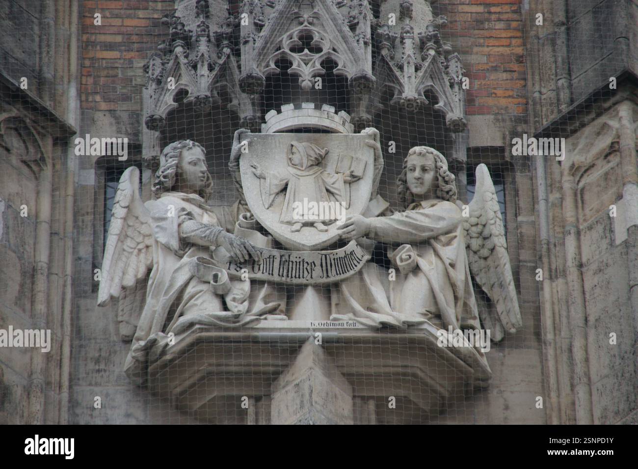 Stone sculpture of two angels in Munich, Germany, holding a shield with ...