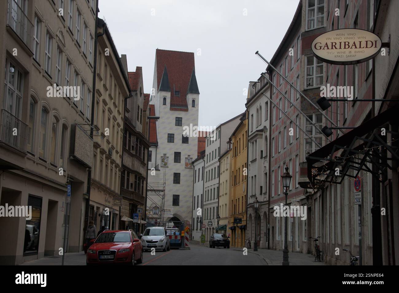 Germany, Munich. A narrow cobblestone street winds between historic ...