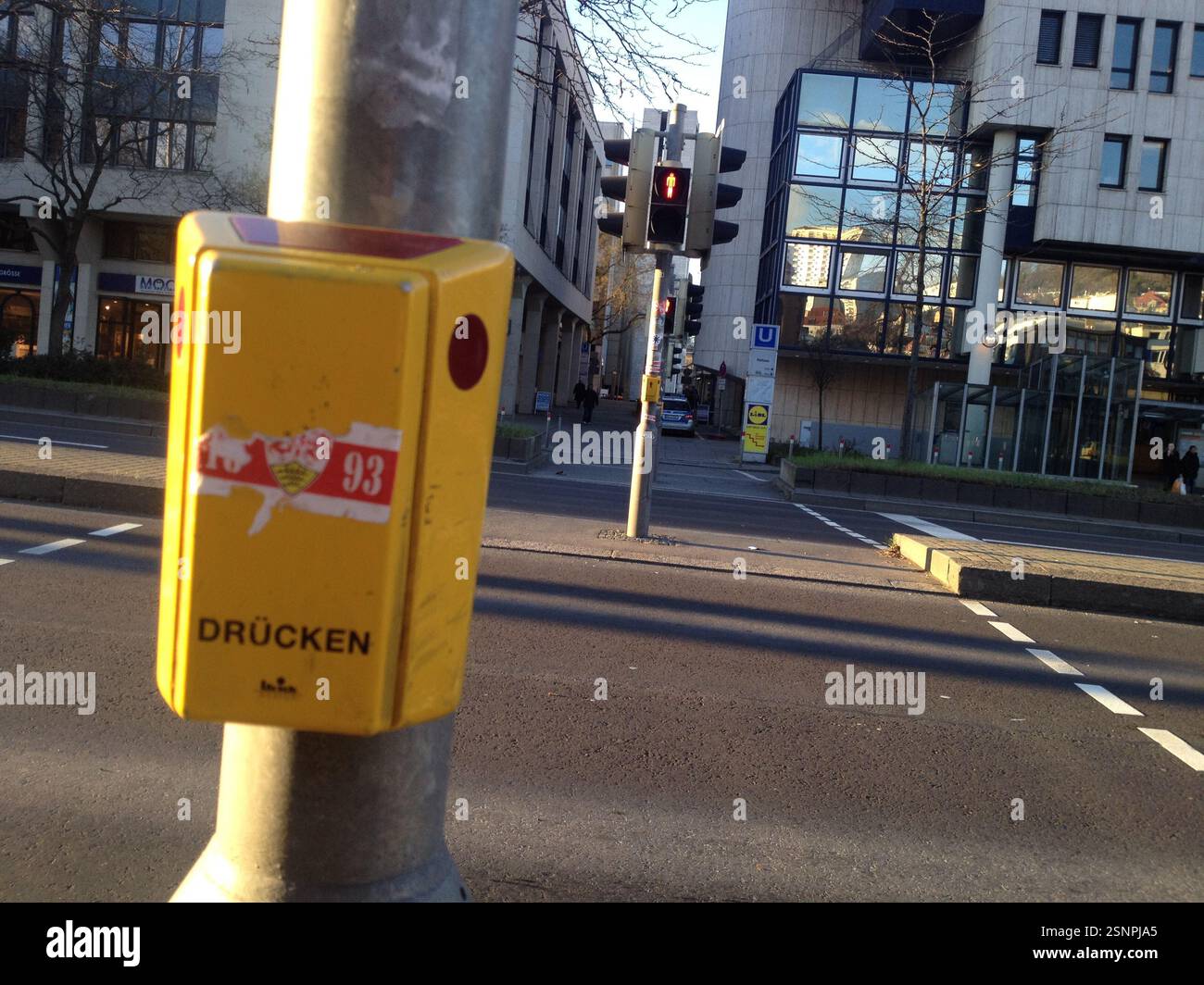 Yellow pedestrian button with "DRÜCKEN" label, mounted on pole, traffic ...
