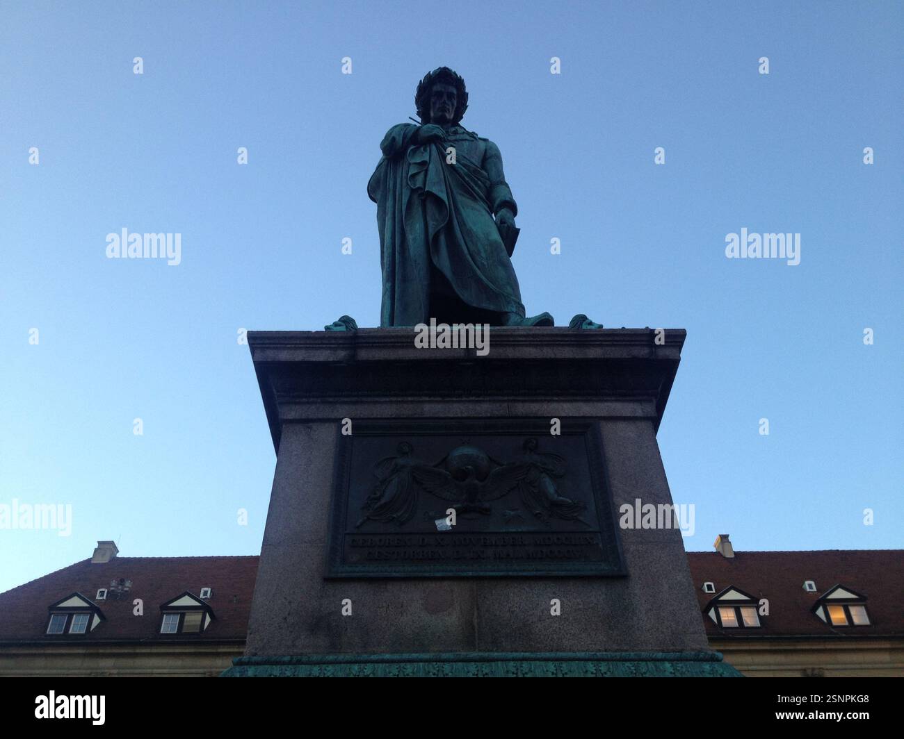 Bronze statue of a man in classical attire, standing on a tall pedestal ...