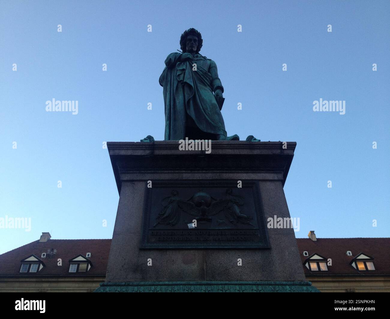 Bronze statue of a man in flowing robe atop tall pedestal, likely a ...