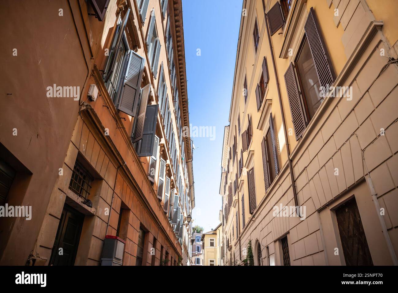 A narrow alleyway in the city’s historic center reveals shutter-lined ...