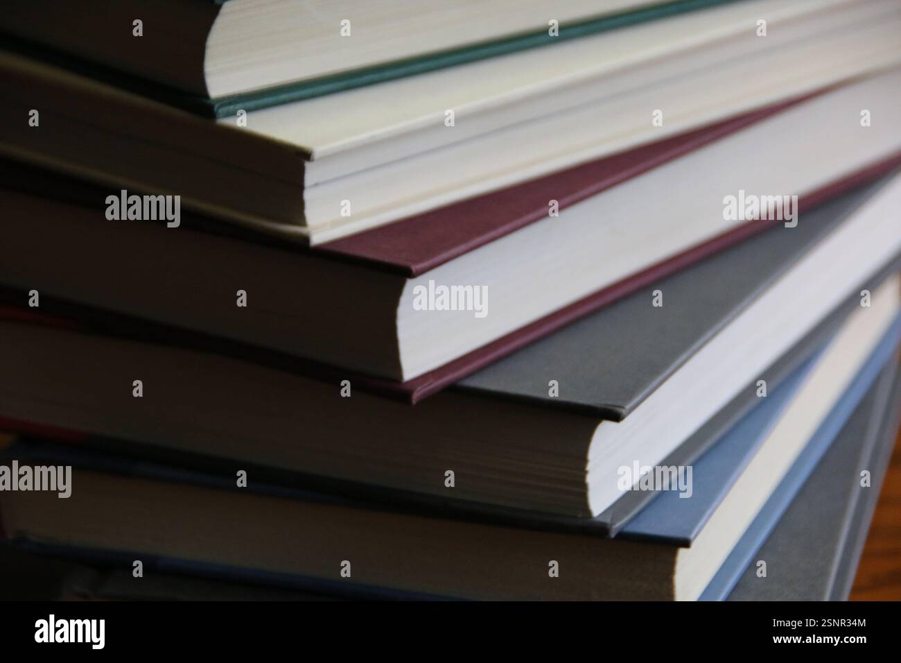 Hardback books stacked in a stair step manner Stock Photo - Alamy