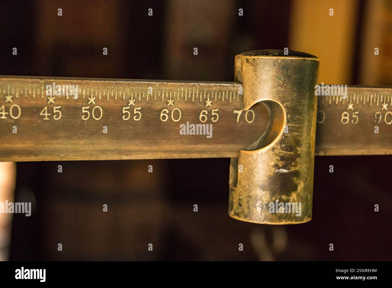 A brass weight and measurement gauge on a vintage industrial warehouse ...