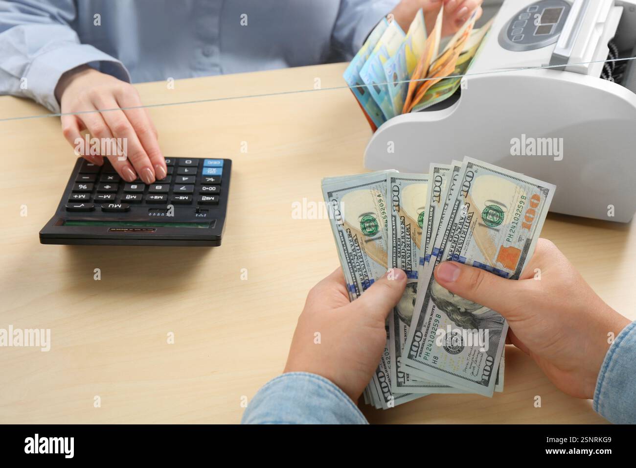 Client counting money at table in currency exchange, closeup Stock ...