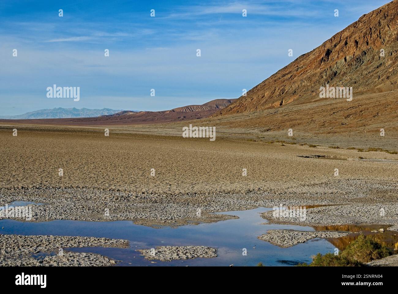 Canyon walls reflect in the waters of Badwater Basin salt flats in ...
