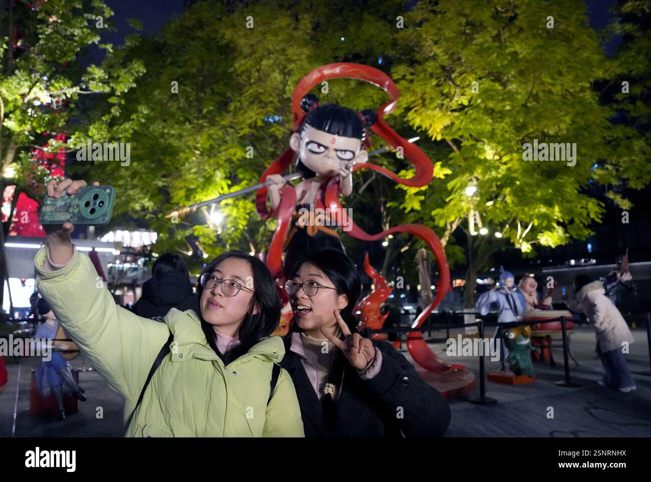Chengdu,China.13th February 2025. Women take a selfie with a sculpture ...