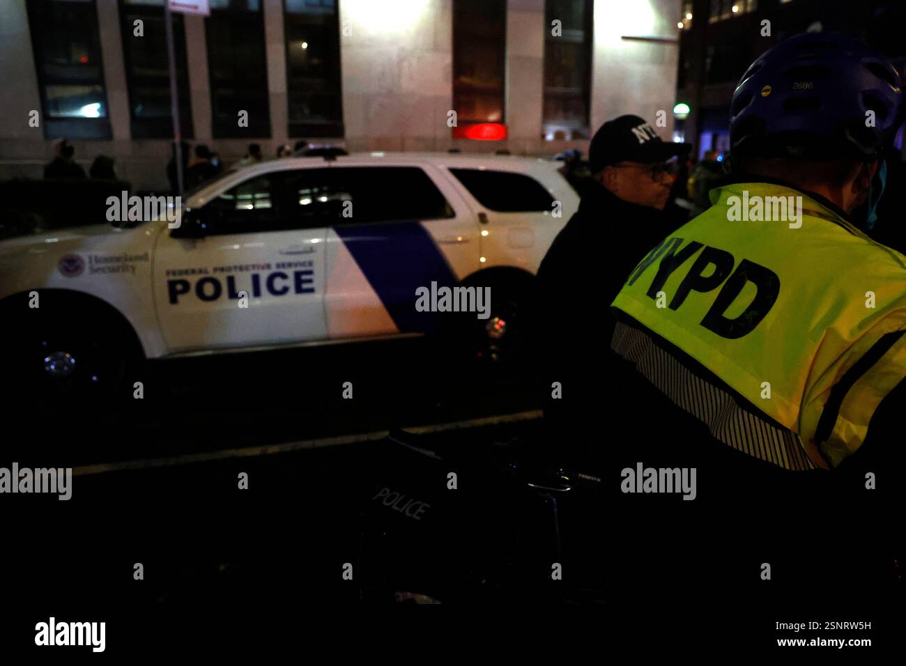 Police officers stand as demonstrators against immigrant deportations ...