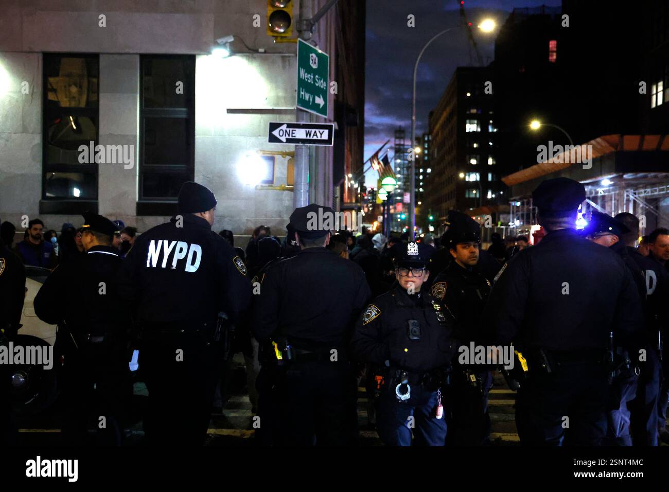 Police officers stand as demonstrators against immigrant deportations ...