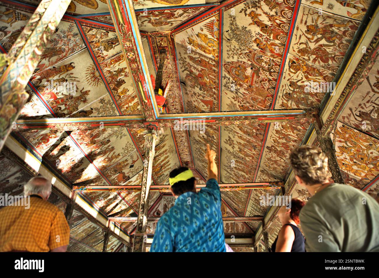 A guide is giving explanation to a group of tourists over the old ...