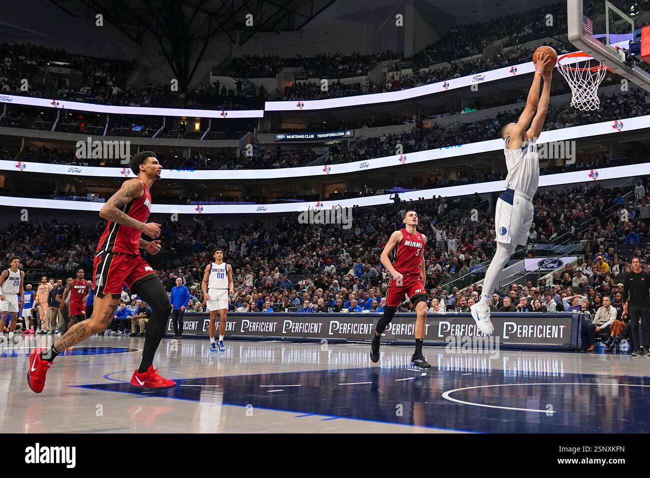 Dallas Mavericks guard Dante Exum, right, scores a basket in front of ...