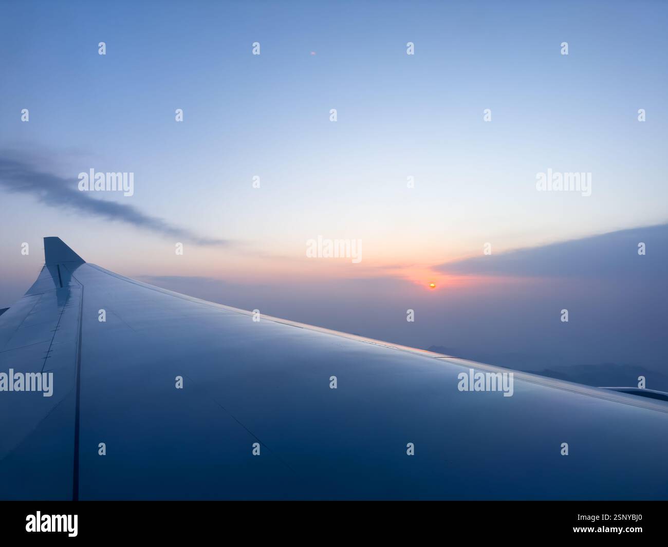 Wing from airplane window on sunset. Great views of landscape. Aerial ...