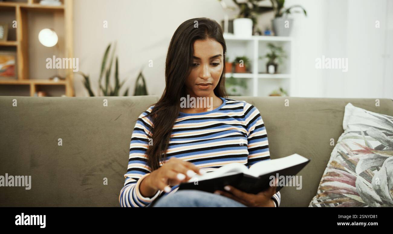 Woman, bible and reading on sofa in home for religion, knowledge and ...