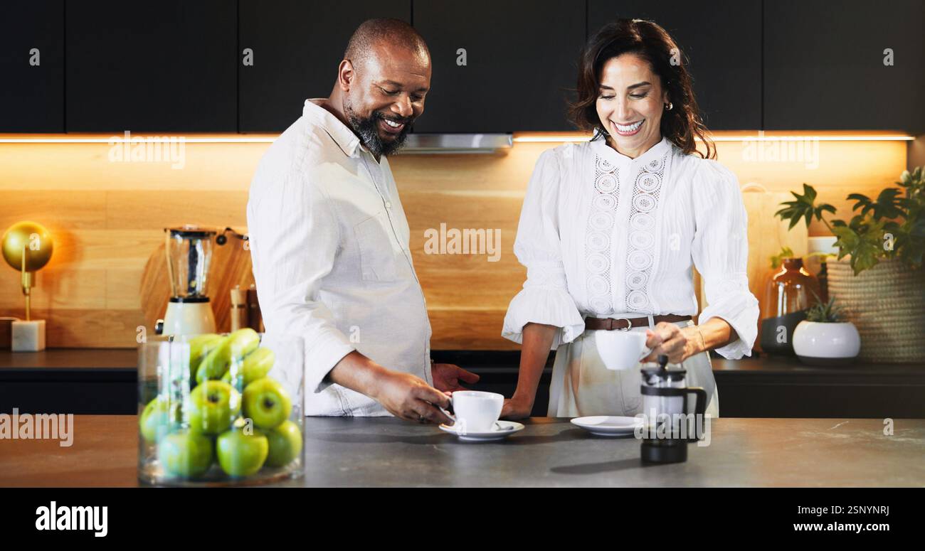 Interracial, couple and relax with coffee in kitchen for caffeine start ...